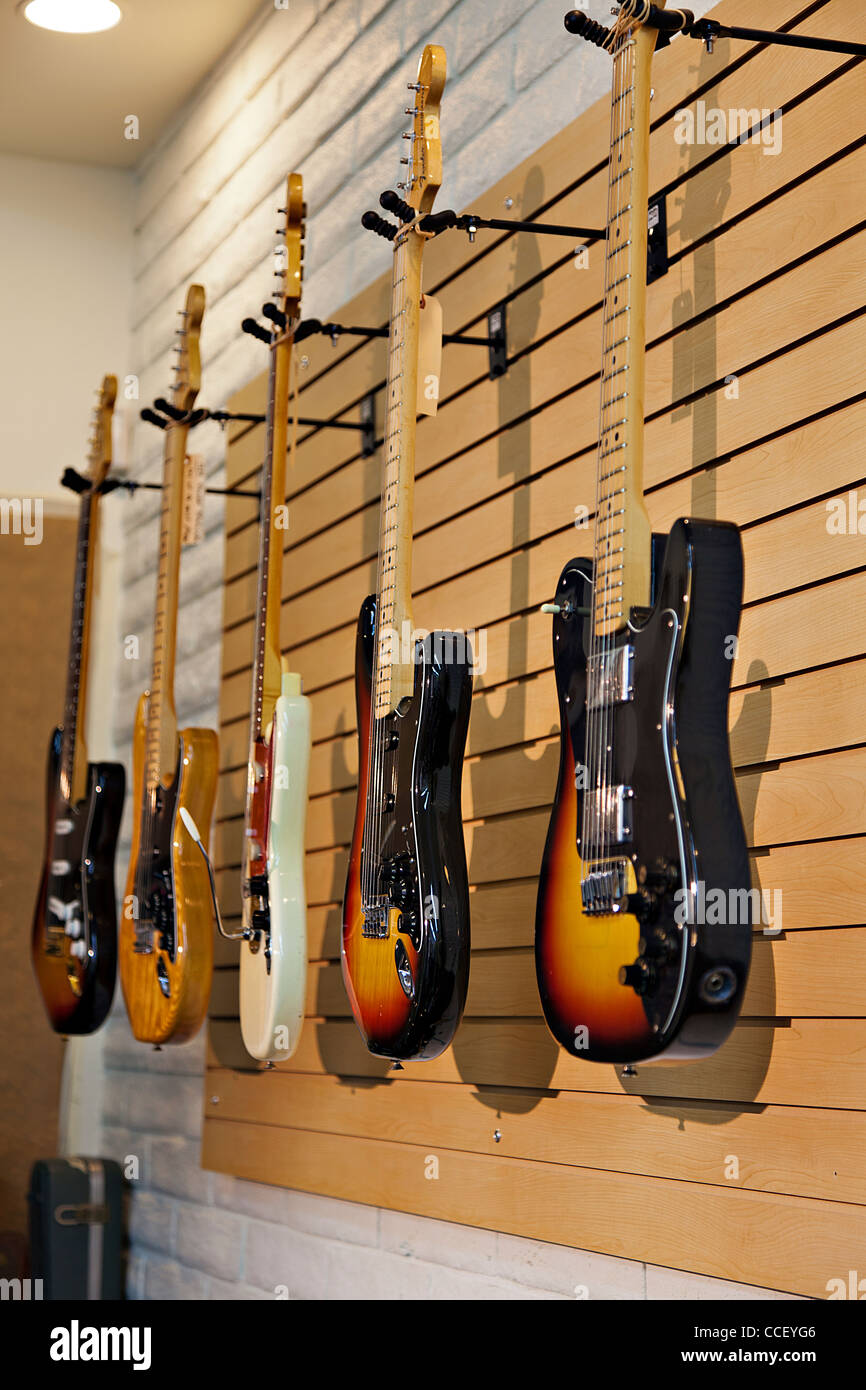 Five electric guitars hanging on display rack in store for sale Stock ...
