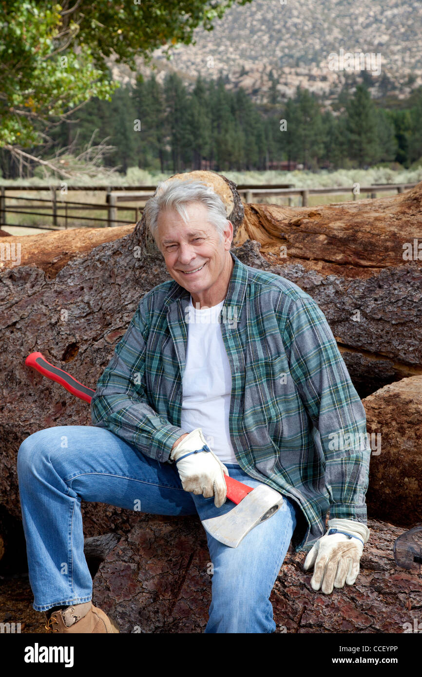Portrait of lumberjack sitting on a pile of logs Stock Photo - Alamy