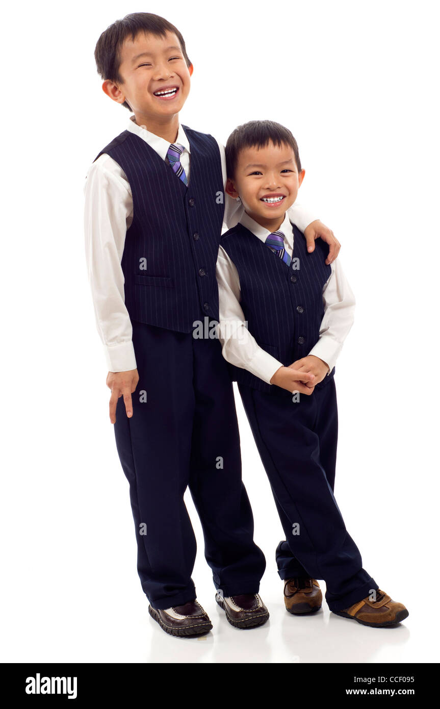 Full length of two happy Asian brothers isolated over white background ...