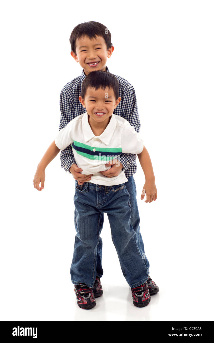 Full length of two boys, siblings, brothers and best friends having fun ...
