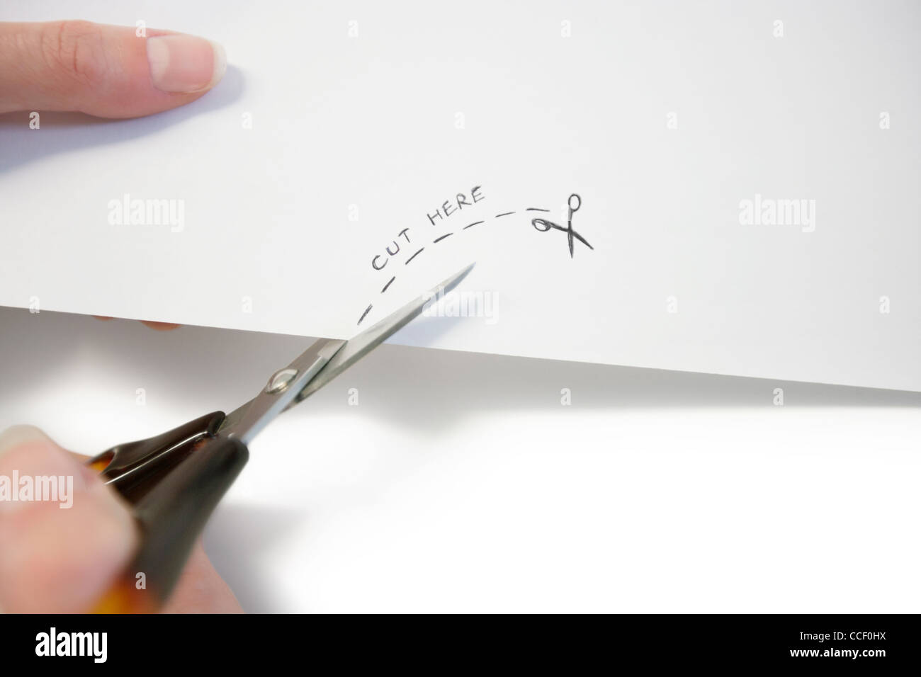 Hand using scissors to cut paper Stock Photo - Alamy