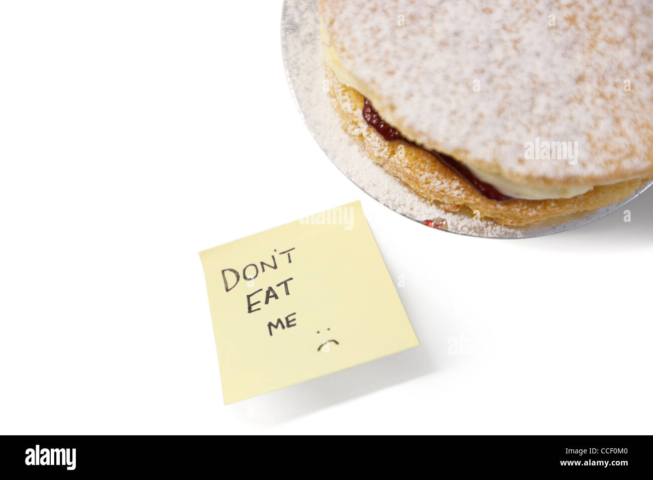 Piece of Victoria sponge cake with 'don't eat me' sign on sticky ...