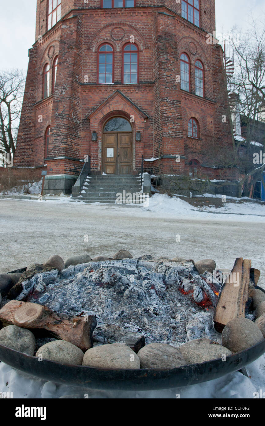 A fire pit warms in front of one of the exhibits in the Skansen Open ...