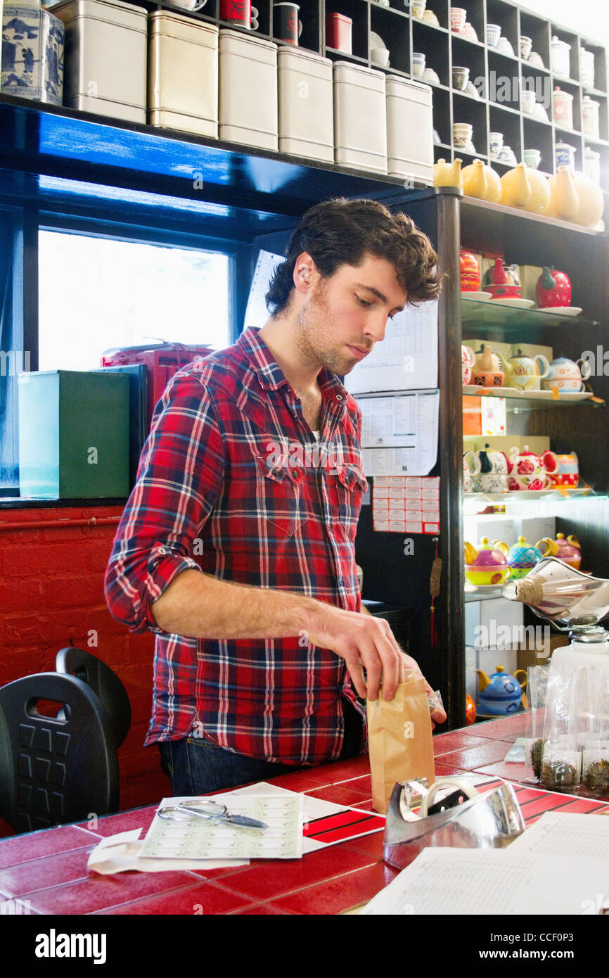 Young man working in tea shop Stock Photo - Alamy