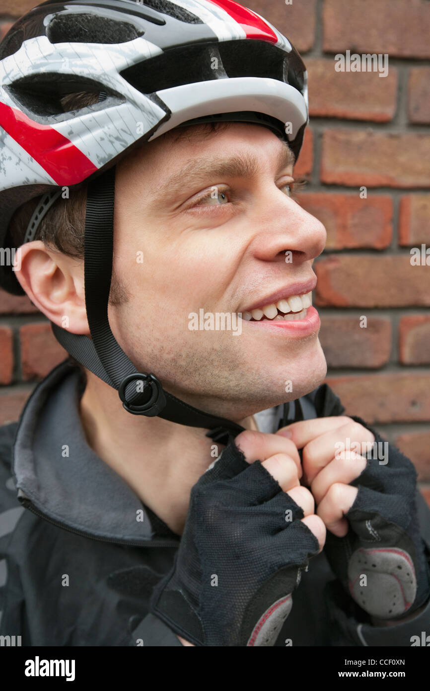 Bicyclist adjusting his helmet Stock Photo - Alamy