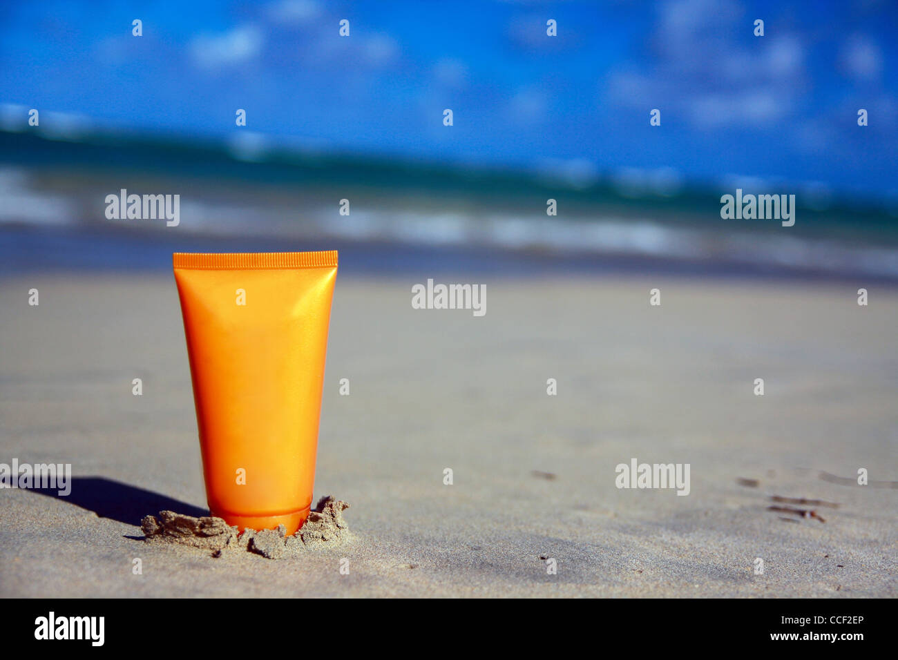 Tube with sun protection on beach of ocean Stock Photo - Alamy