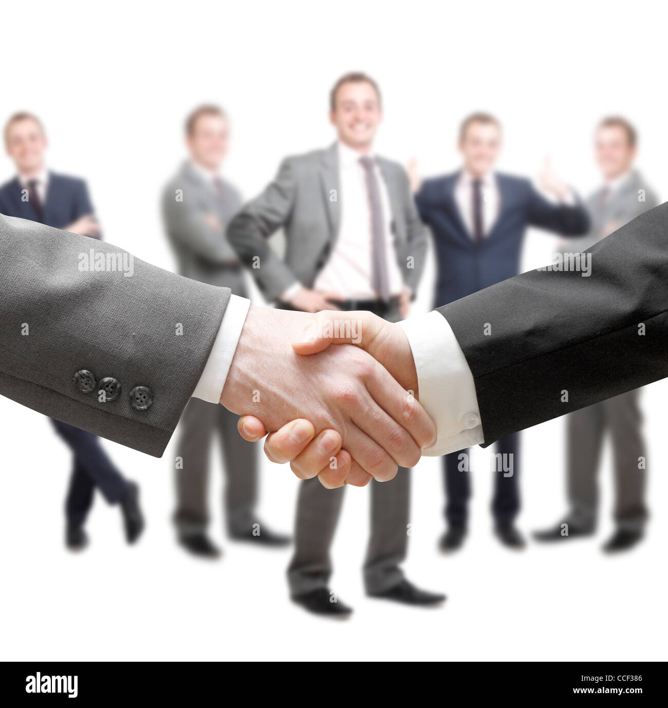 Businessmen in a group and a handshake Stock Photo - Alamy