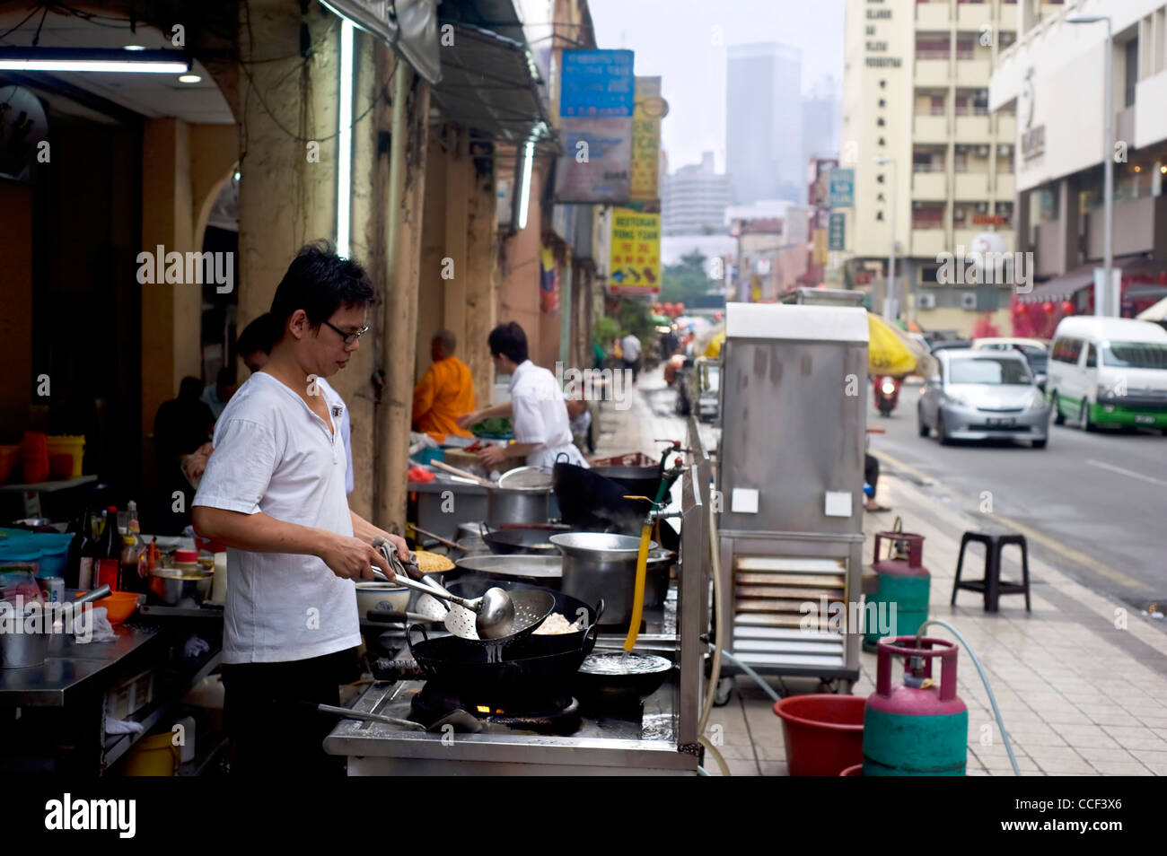 Local man cooking fast food on the street in Kuala Lumpur's Chinatown ...