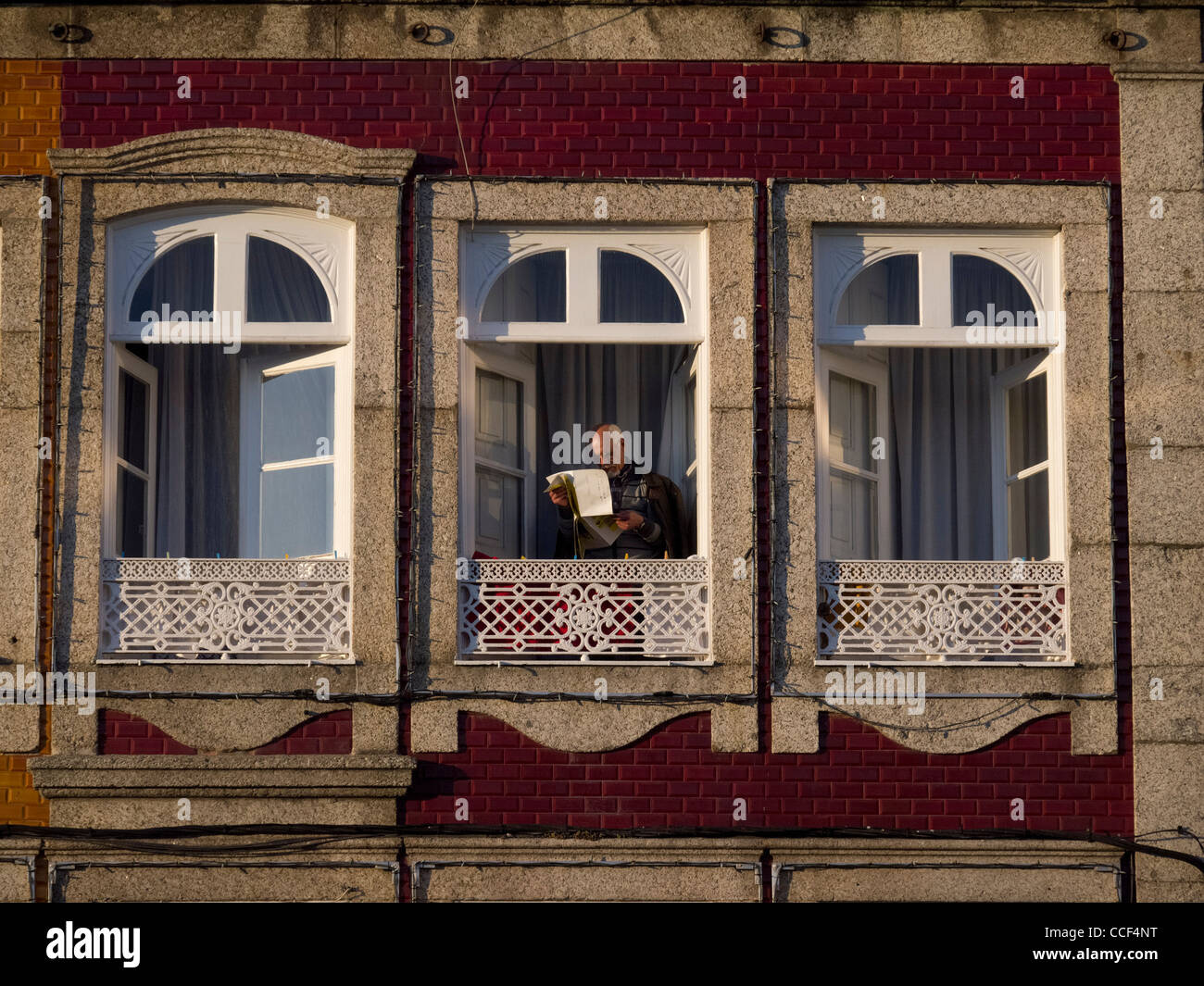 Man reading newspaper at the window Stock Photo - Alamy