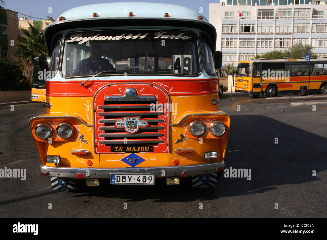 Traditional yellow and orange vintage bus at Bugibba bus station in ...