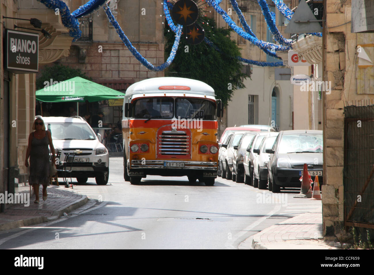 Traditional yellow and orange vintage bus on the street of Mosta in ...