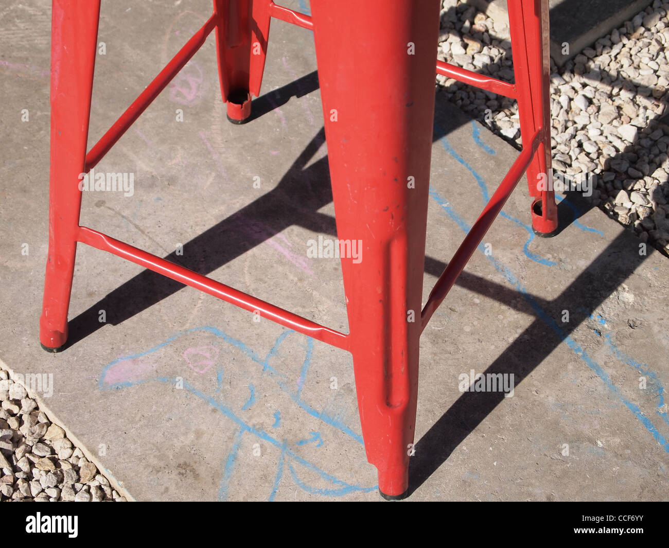 a red cafe stool on a concrete slab Stock Photo - Alamy