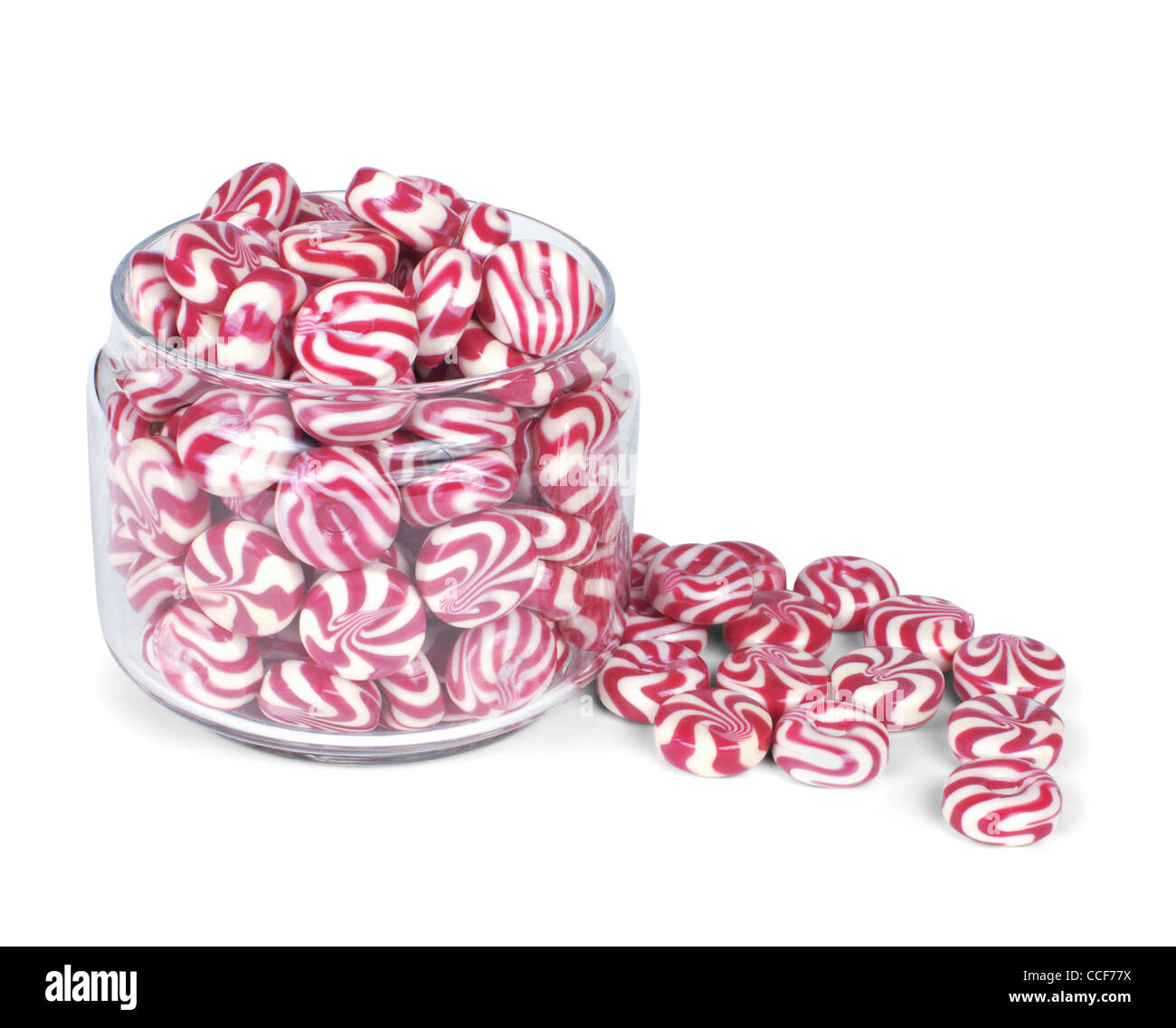 Glass jar full of red striped caramel sweets isolated on white ...