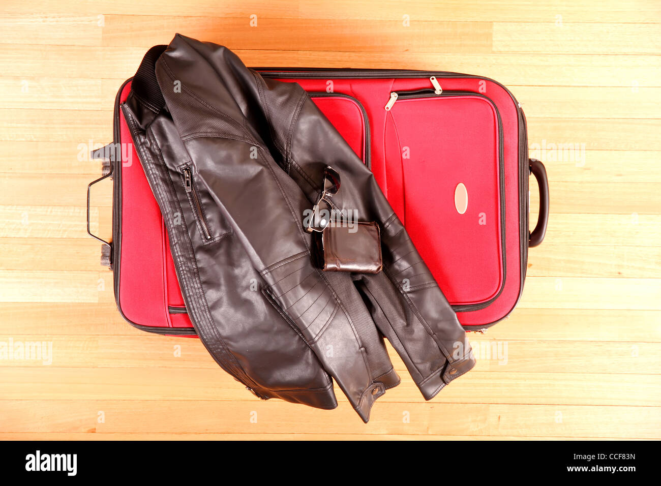 Ready to travel. A suitcase with glasses, wallet and a leather jacket ...