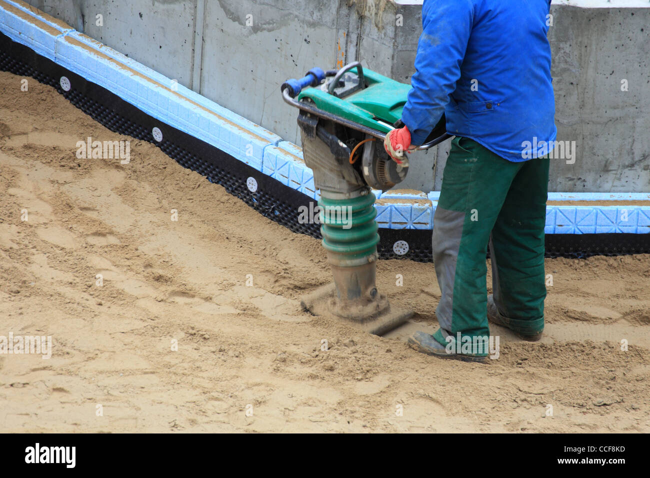 Worker at site working with compress tool - sand Stock Photo - Alamy