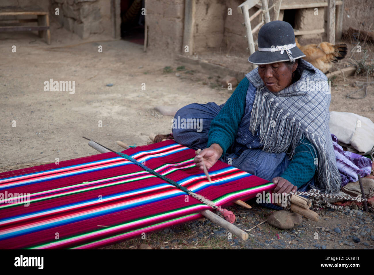 An Aymara woman weaves on a traditional hand loom in Huatajata on the ...