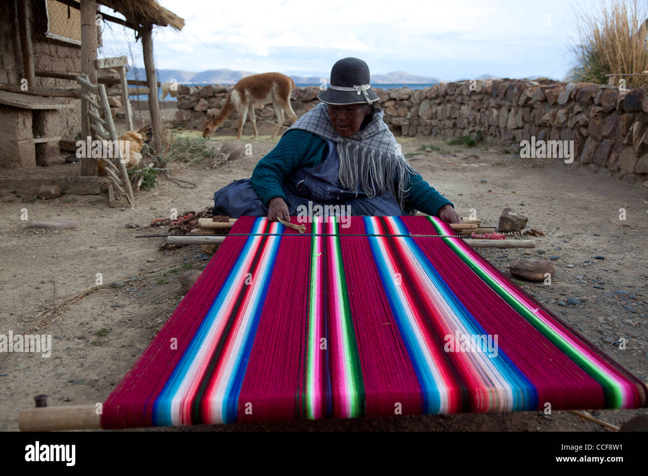 An Aymara woman weaves on a traditional hand loom in Huatajata on the ...