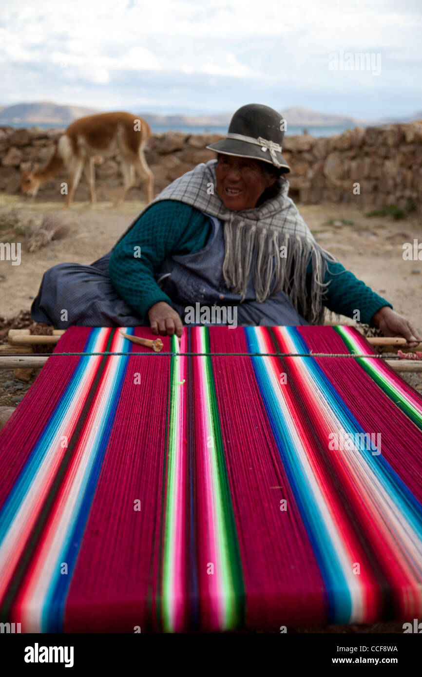An Aymara woman weaves on a traditional hand loom in Huatajata on the ...