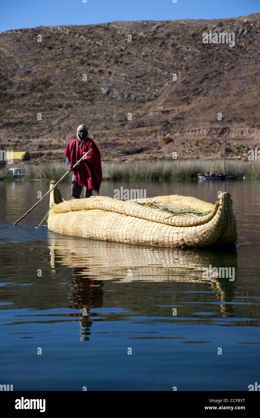 An Aymara man pushes a tortora reed raft on the Bolivian side of Lake ...