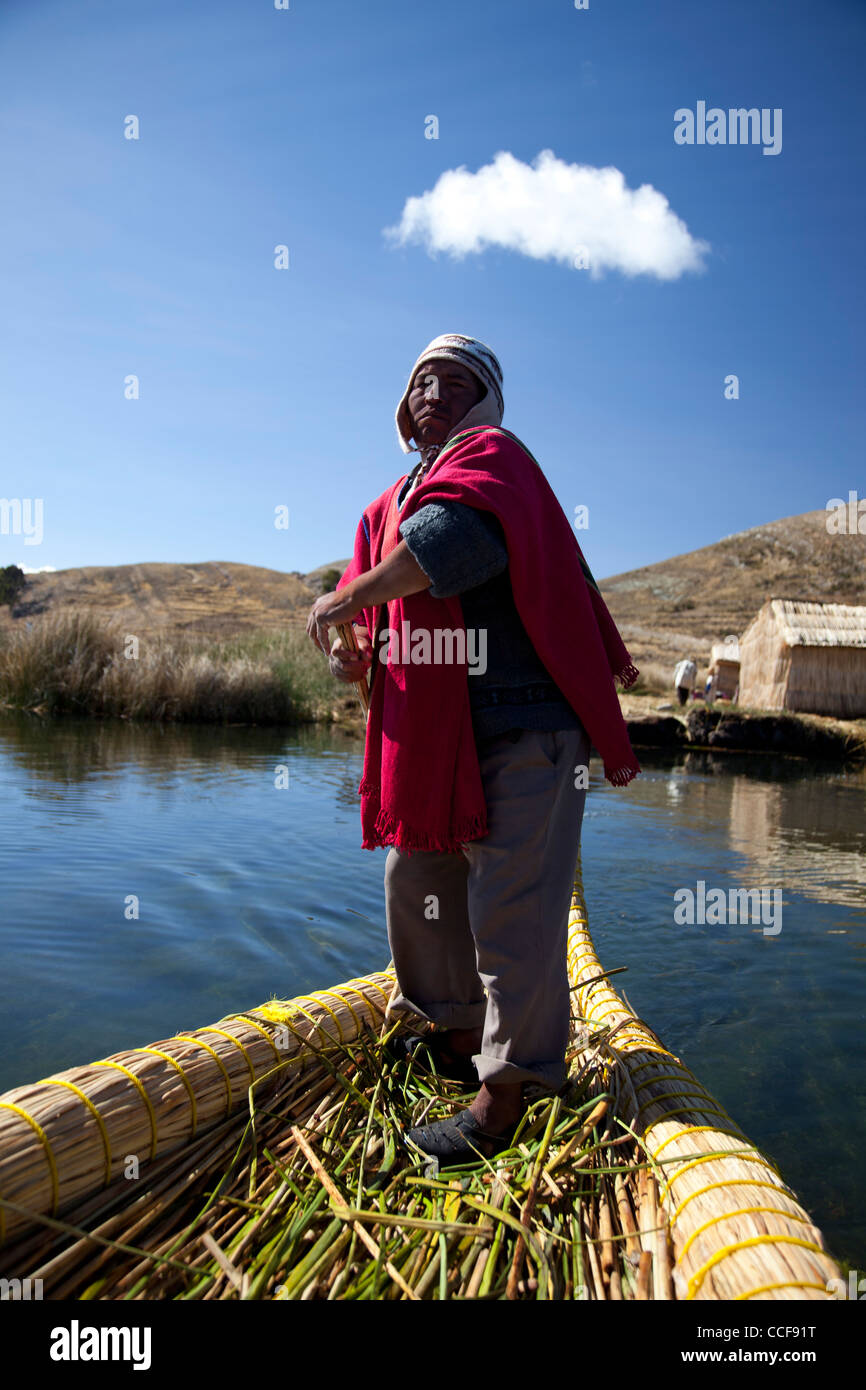 An Aymara man pushes a tortora reed raft on the Bolivian side of Lake ...