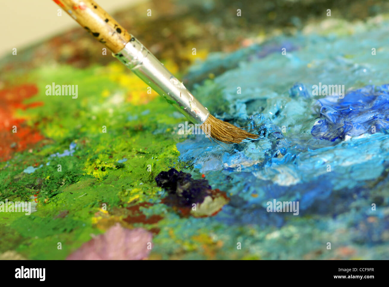 big paintbrush is mixing colors on palette. Shallow DOF Stock Photo - Alamy