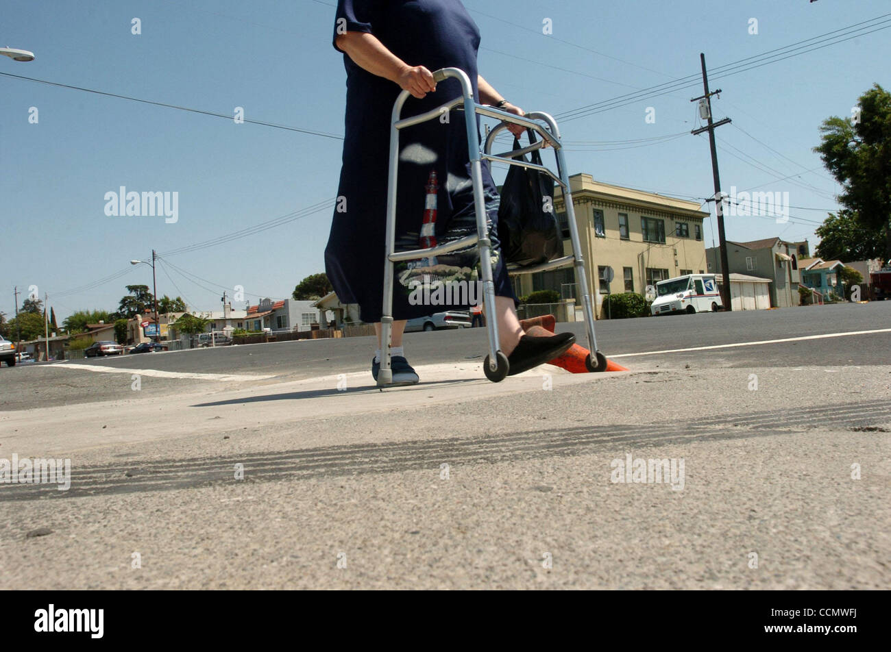 A pedestrian walks up a handicap sidewalk ramp on10th Street in ...