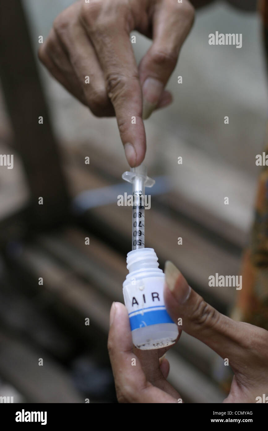 JAKARTA, INDONESIA JULY 14, 2004 A junkie cleans his needle with water ...
