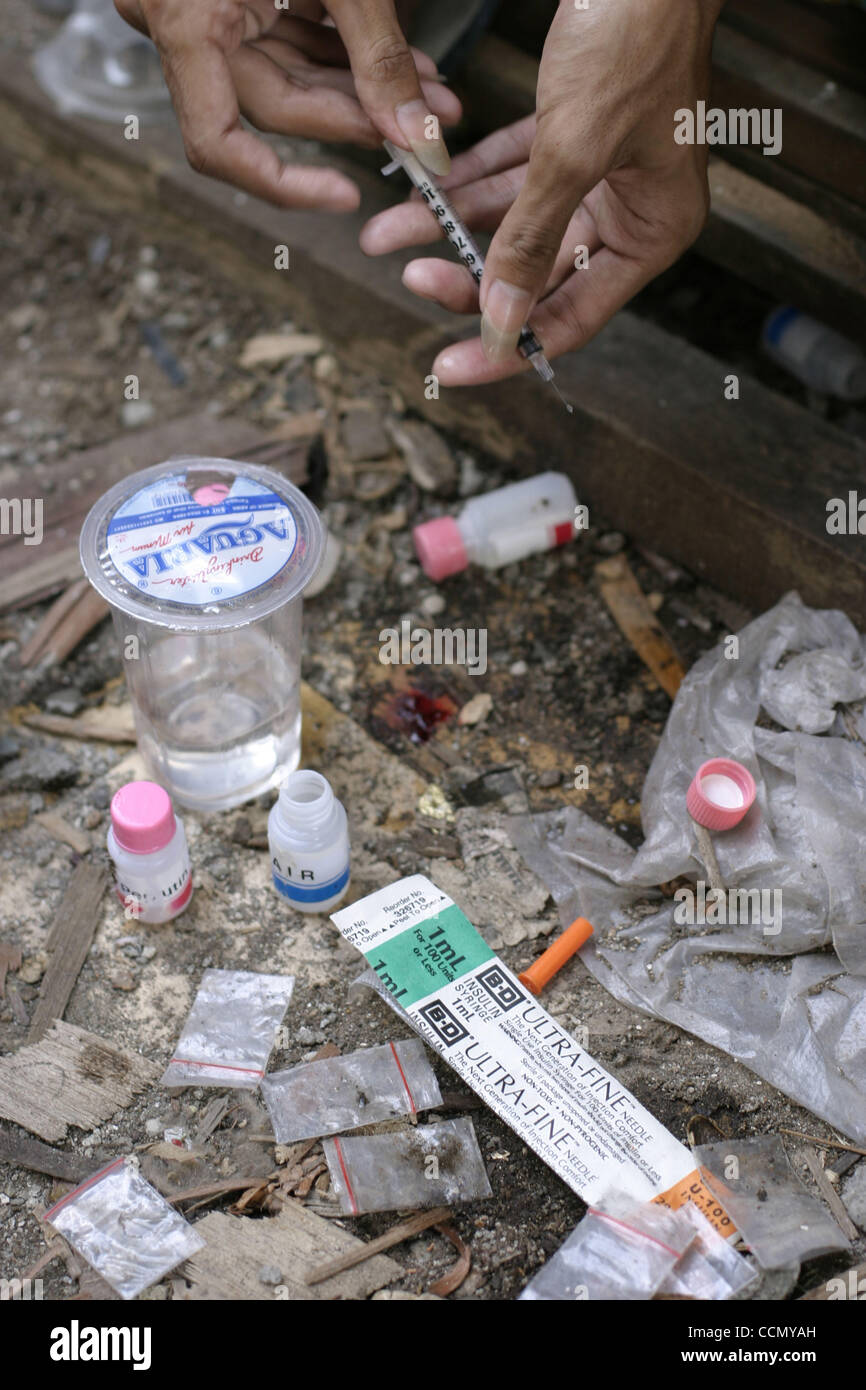 JAKARTA, INDONESIA JULY 14, 2004 A junkie cleans his needle with water ...