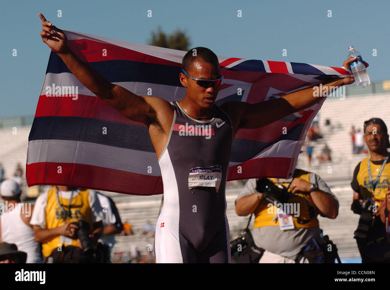 Bryan Clay holds up the Hawaiian flag after winning the Men's Decathlon ...