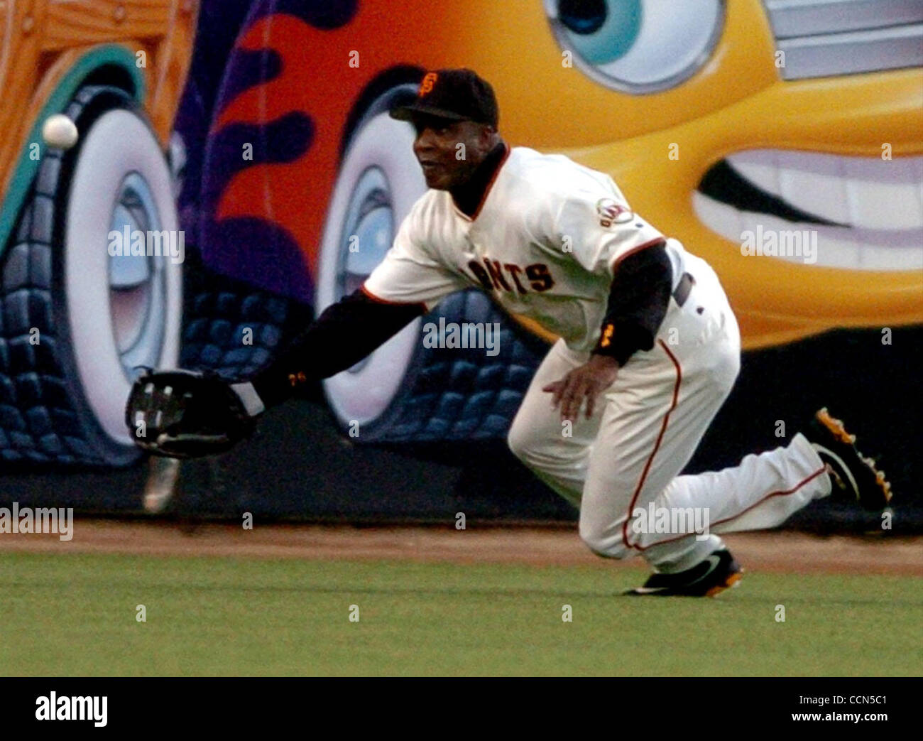 Barry Bonds of the Giants misses the long drive by Ken Griffey Jr. of ...