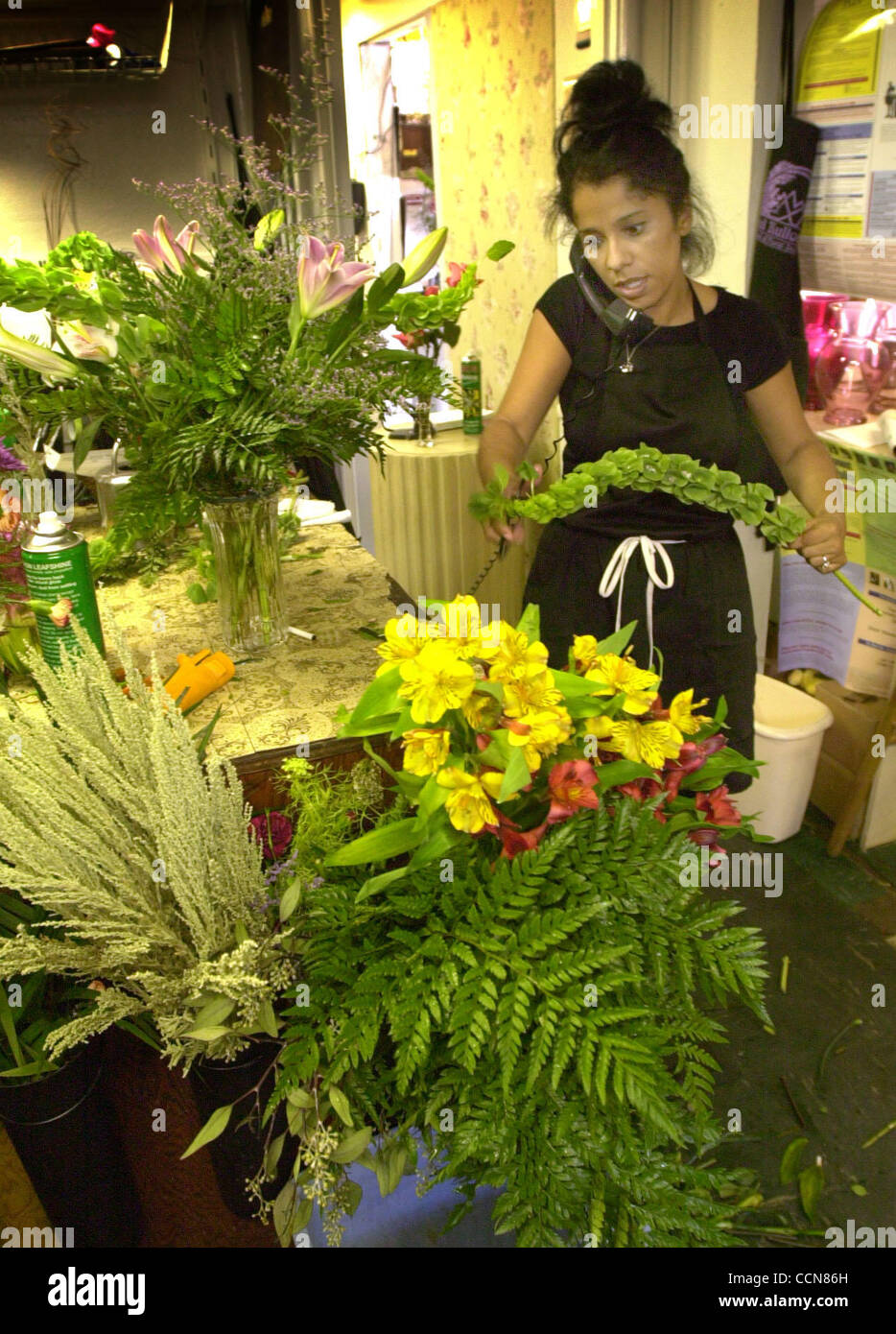 10:43 am: Cottage Florist owner Kay Trail multitasks as she arranges a ...