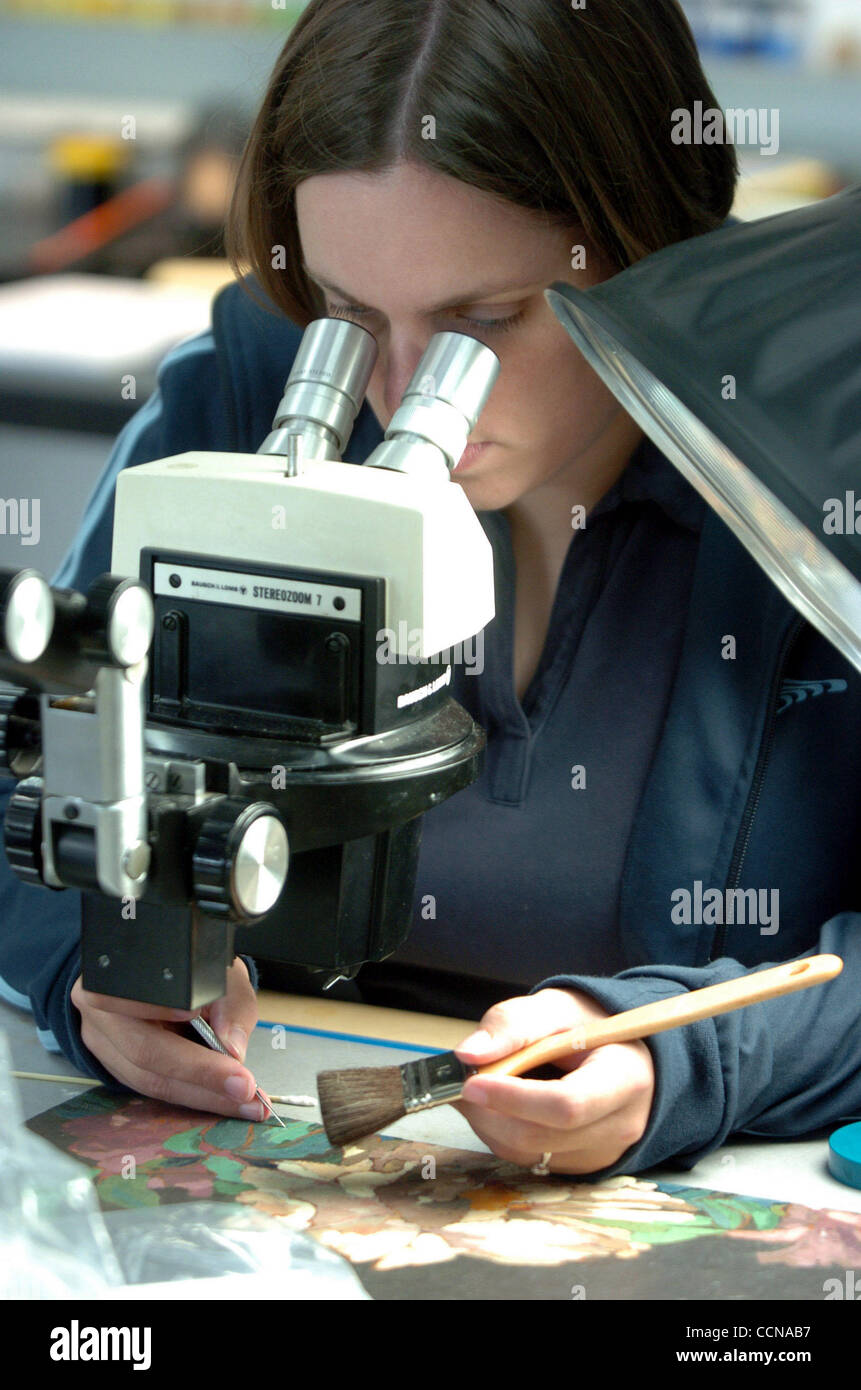 Associate conservator Pam Skiles uses a microscope to restore a ...