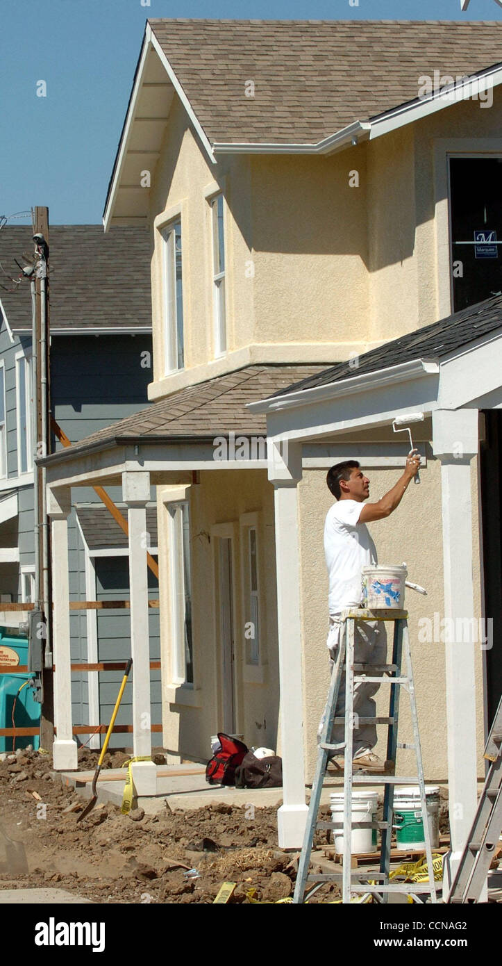 Victor Matos (cq) paints white trim on a home at the new Nantucket Cove ...