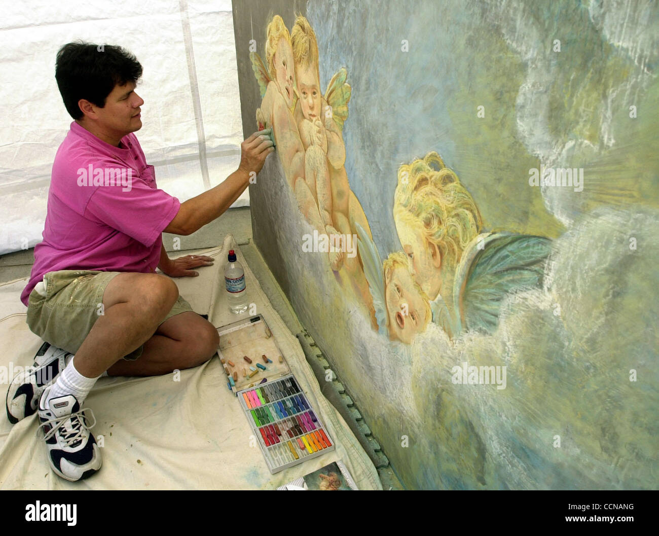 Artist Manuel Cruz III works on a chalk mural at the plaza along Main ...