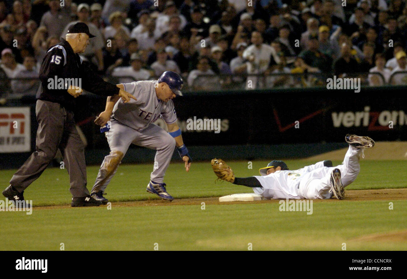 A's third baseman Eric Chavez (right) reaches for Ranger Kevin Mench ...