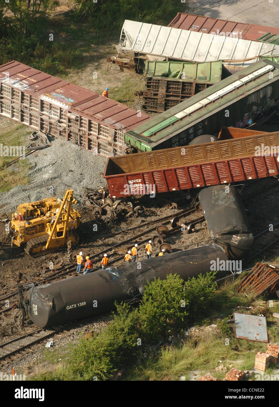 METRO - Railroad workers look over damaged rail cars belonging to the ...