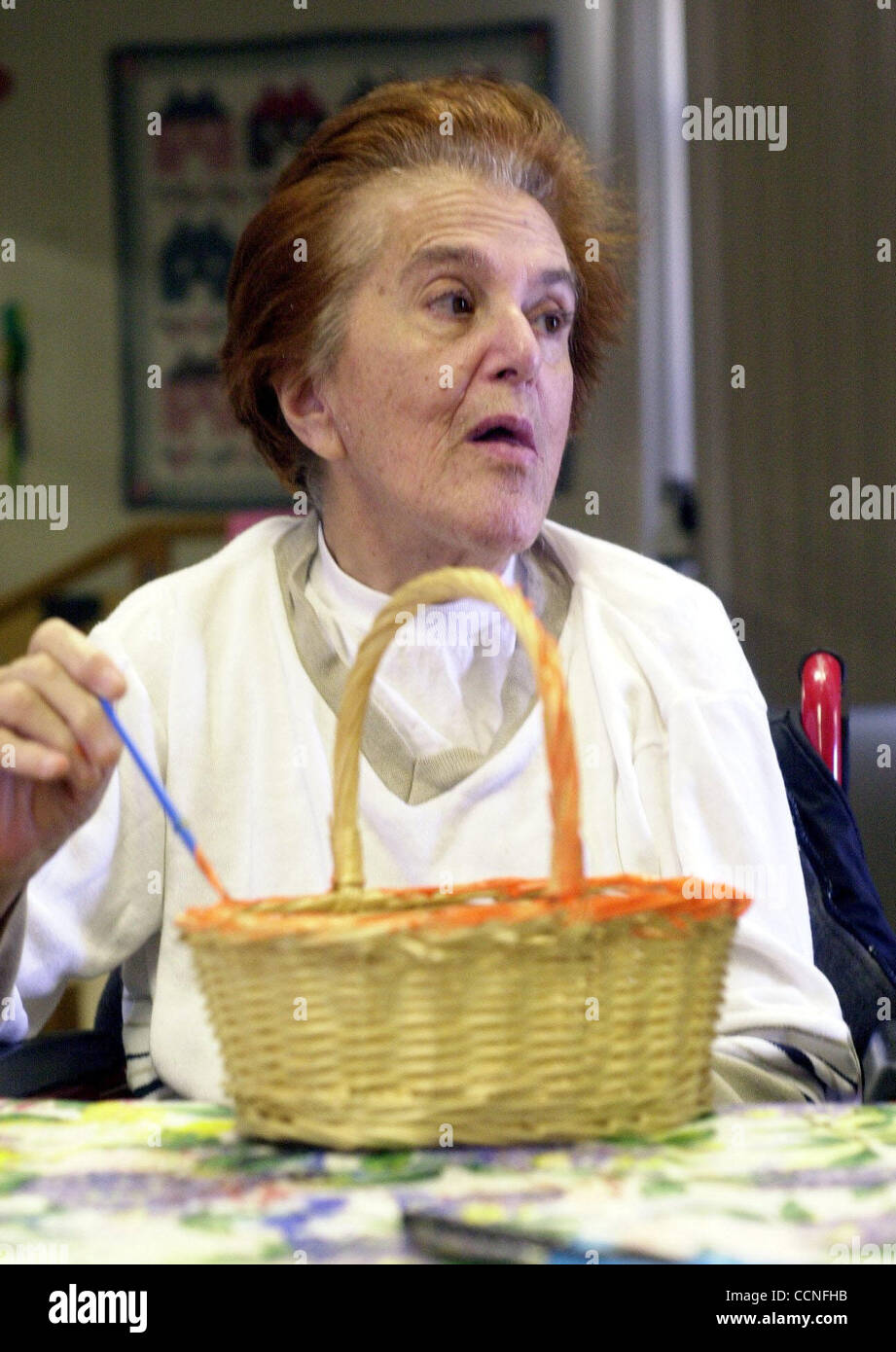 Florencia Rios, 72, paints a basket during an arts and craft activity ...