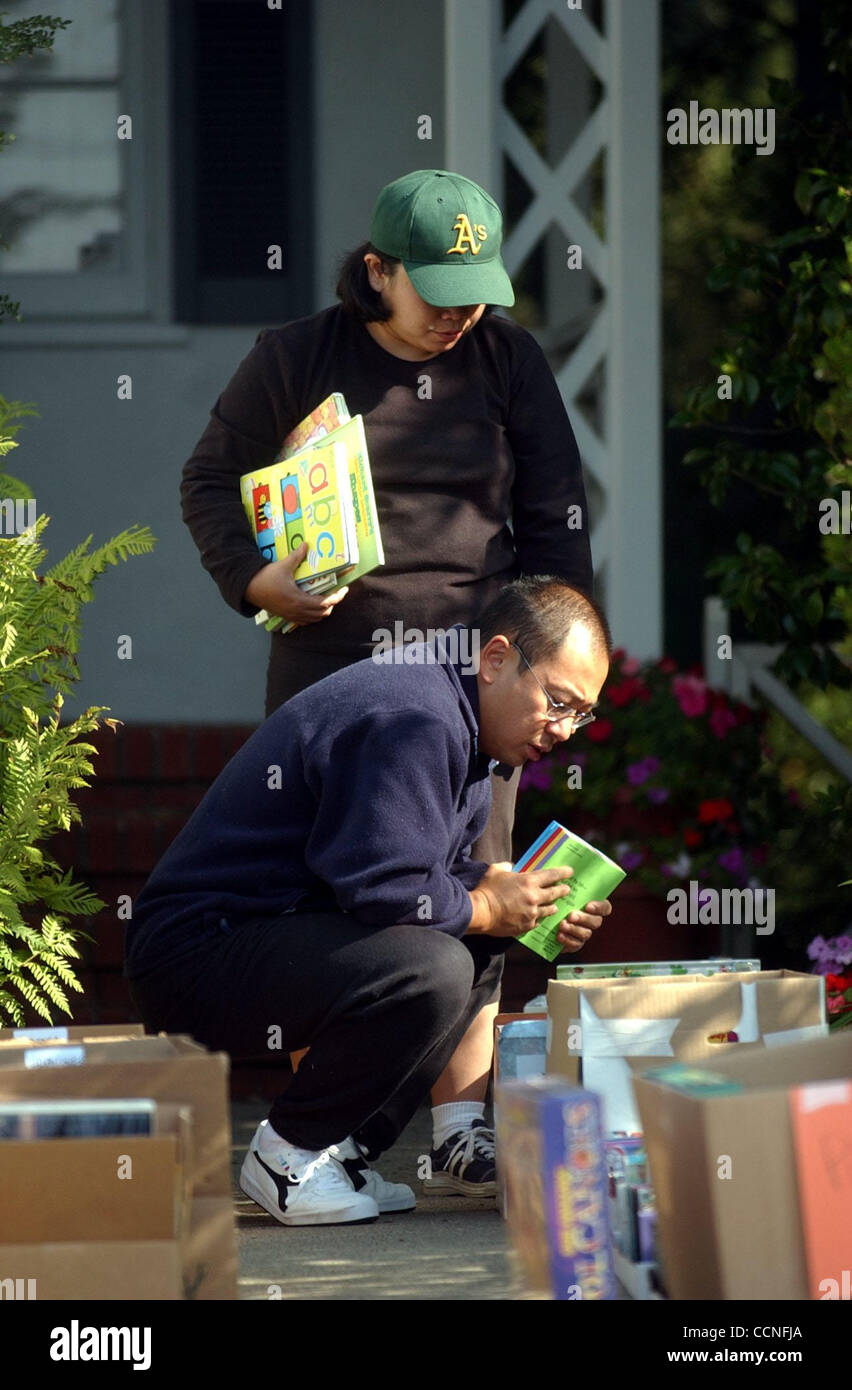 Shoppers Alan Chu and his wife Hartini Chu look over the books for sale ...