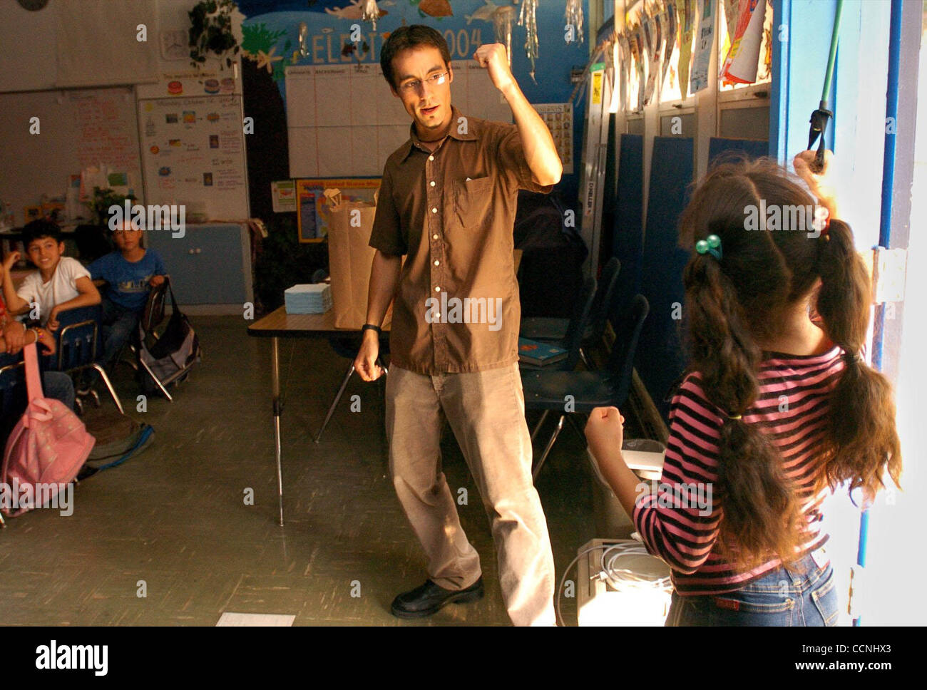 (L TO R) Teacher Jacob Lawlor tells Perla Posadas, 9, to try to stretch ...