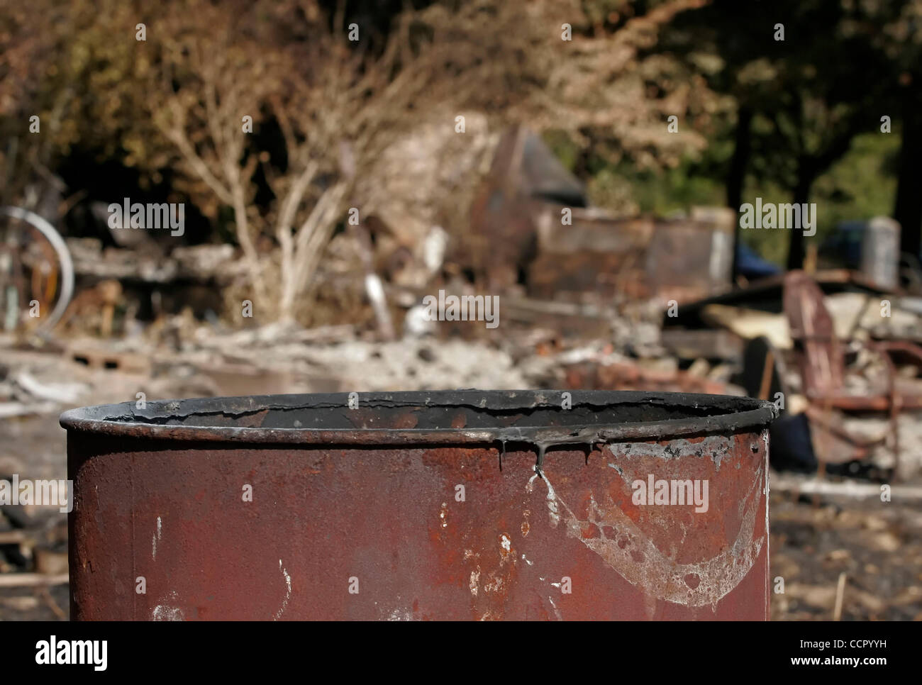 A burn barrel still smolders near the remains of the Cranick family's ...