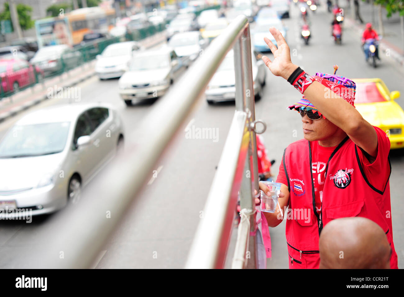 A Red Shirt riding on a truck waves at Bangkokians. Motorcade carry Red ...