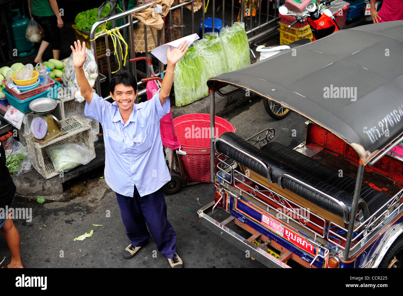 A Tuk-Tuk driver waves at Red Shirts' motorcade. Motorcade carry Red ...