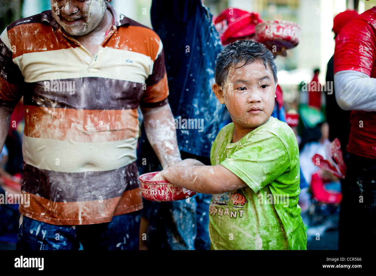 A boy prepares powder in his bucket during the Songkran festival at ...