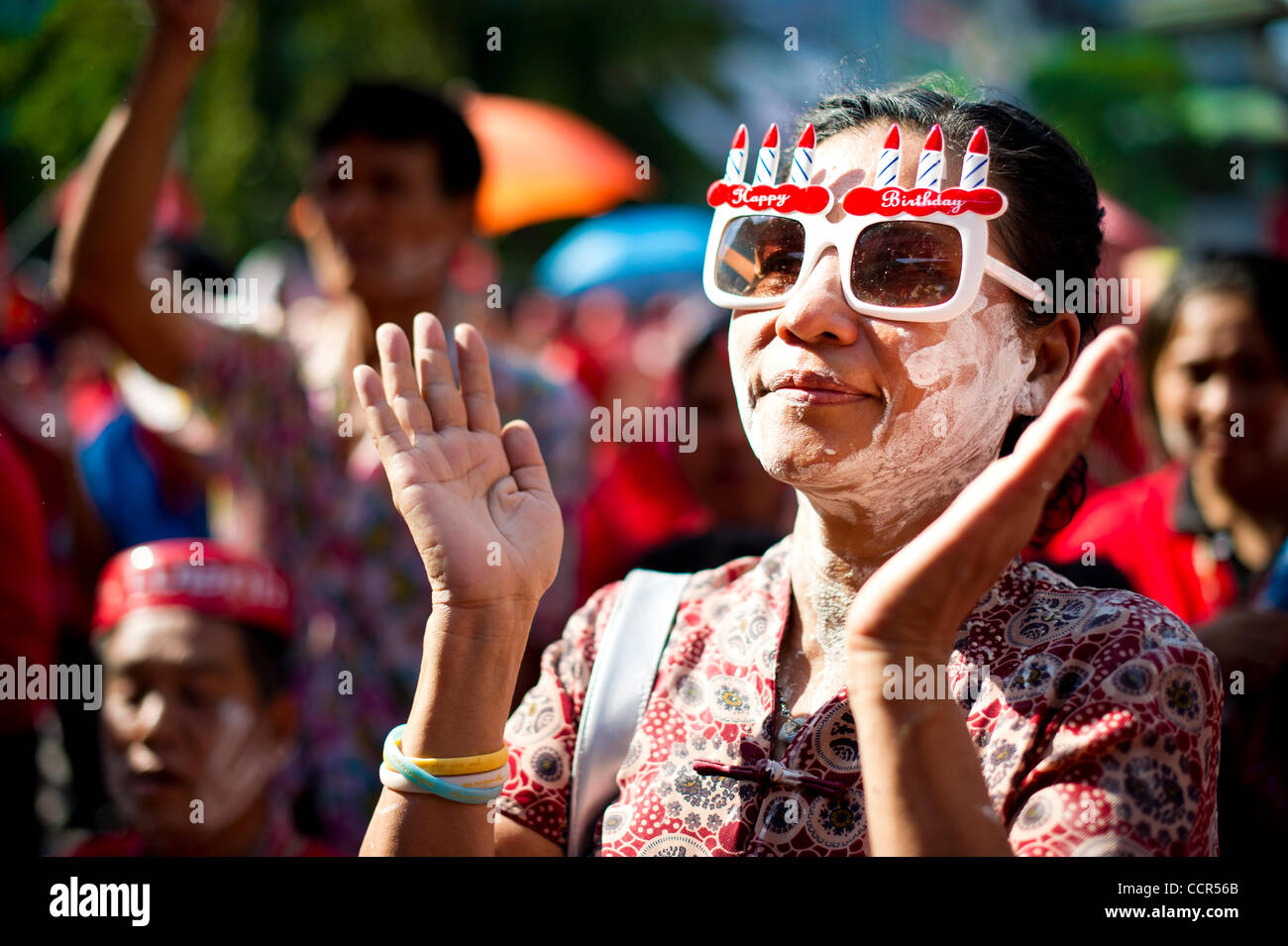 A member of Red Shirts claps during the Songkran festival at ...