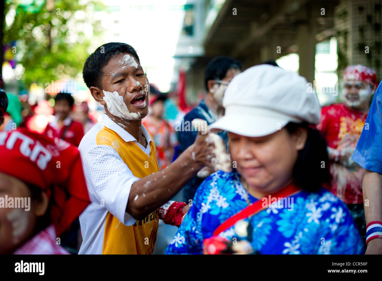 A man applies powder to passing locals during the Songkran festival at ...