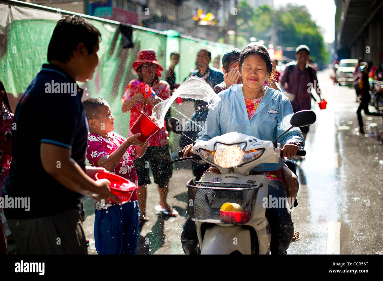 Red Shirts splash passing by motorist with water during the Songkran ...