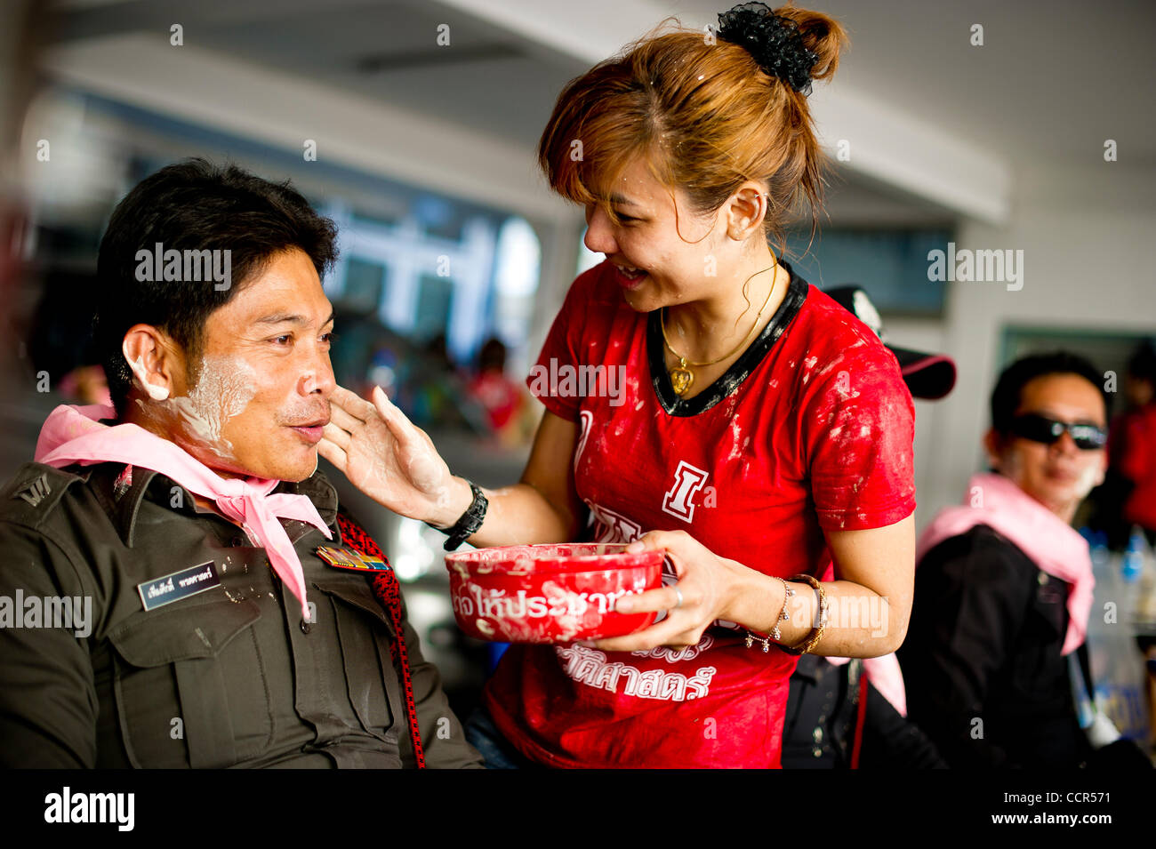 A member of Red Shirts applies powder to policemen during the Songkran ...