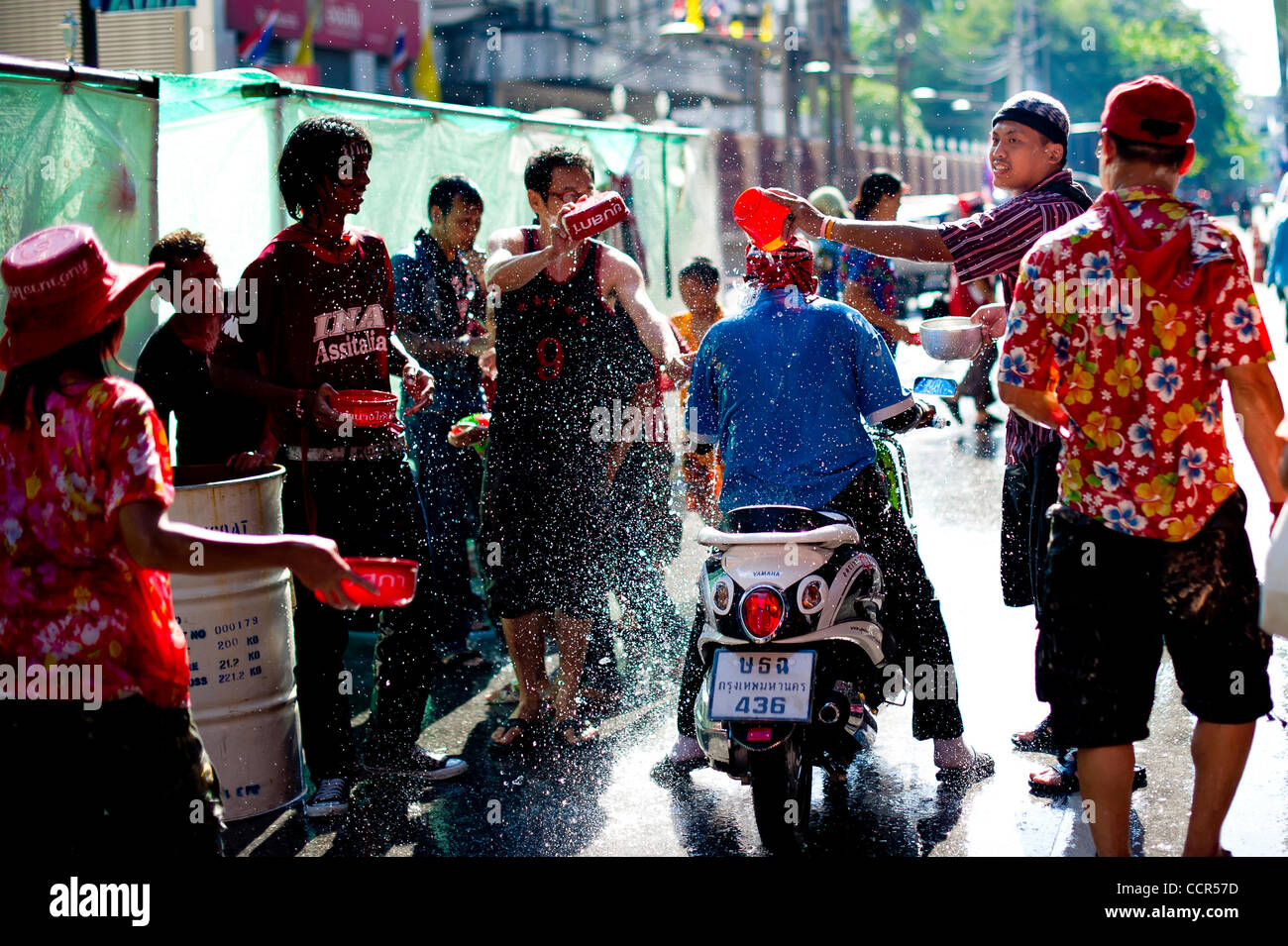 Red Shirts splash passing by motorist with water during the Songkran ...