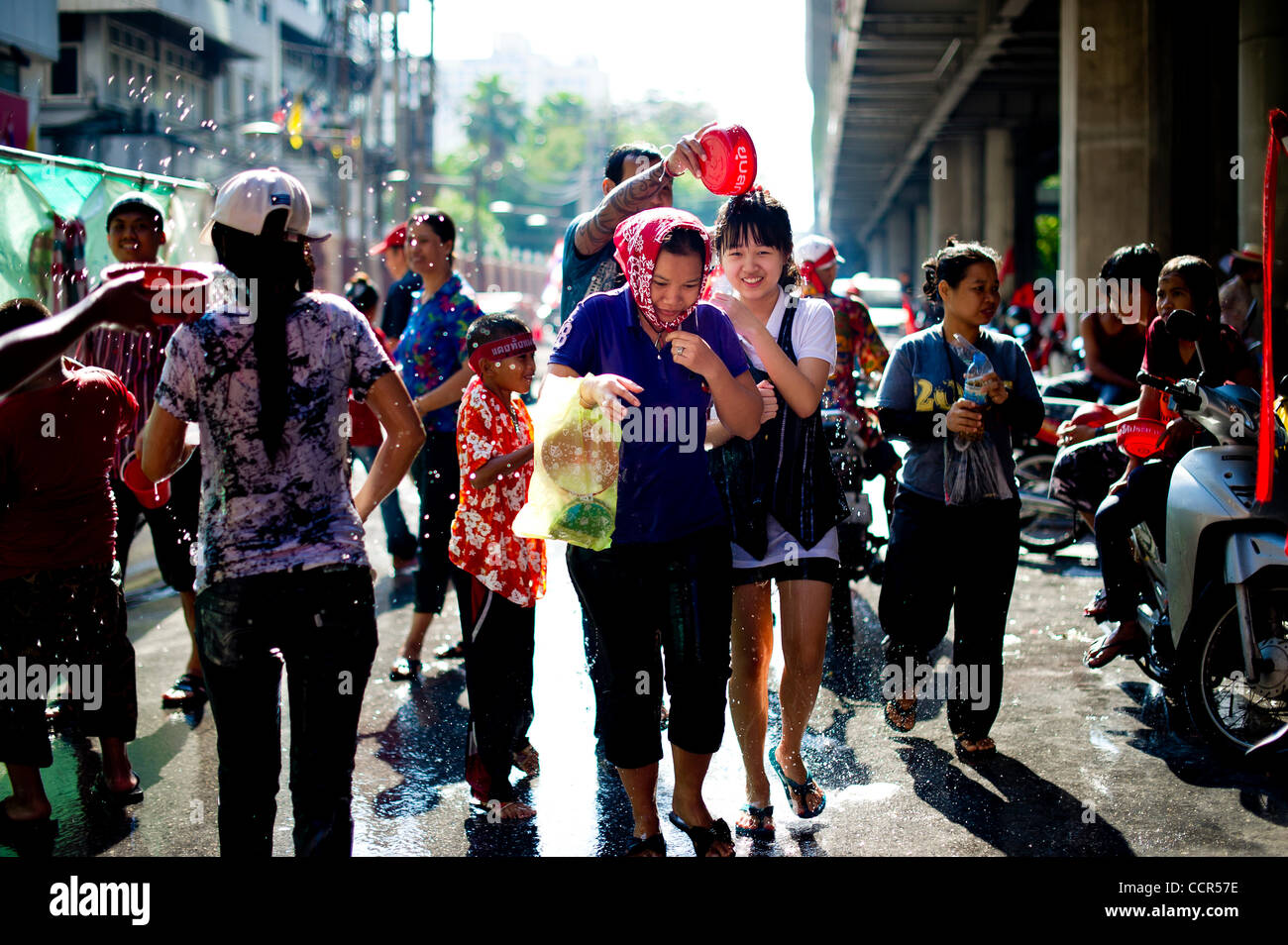Red Shirts splash people walking by with water during the Songkran ...