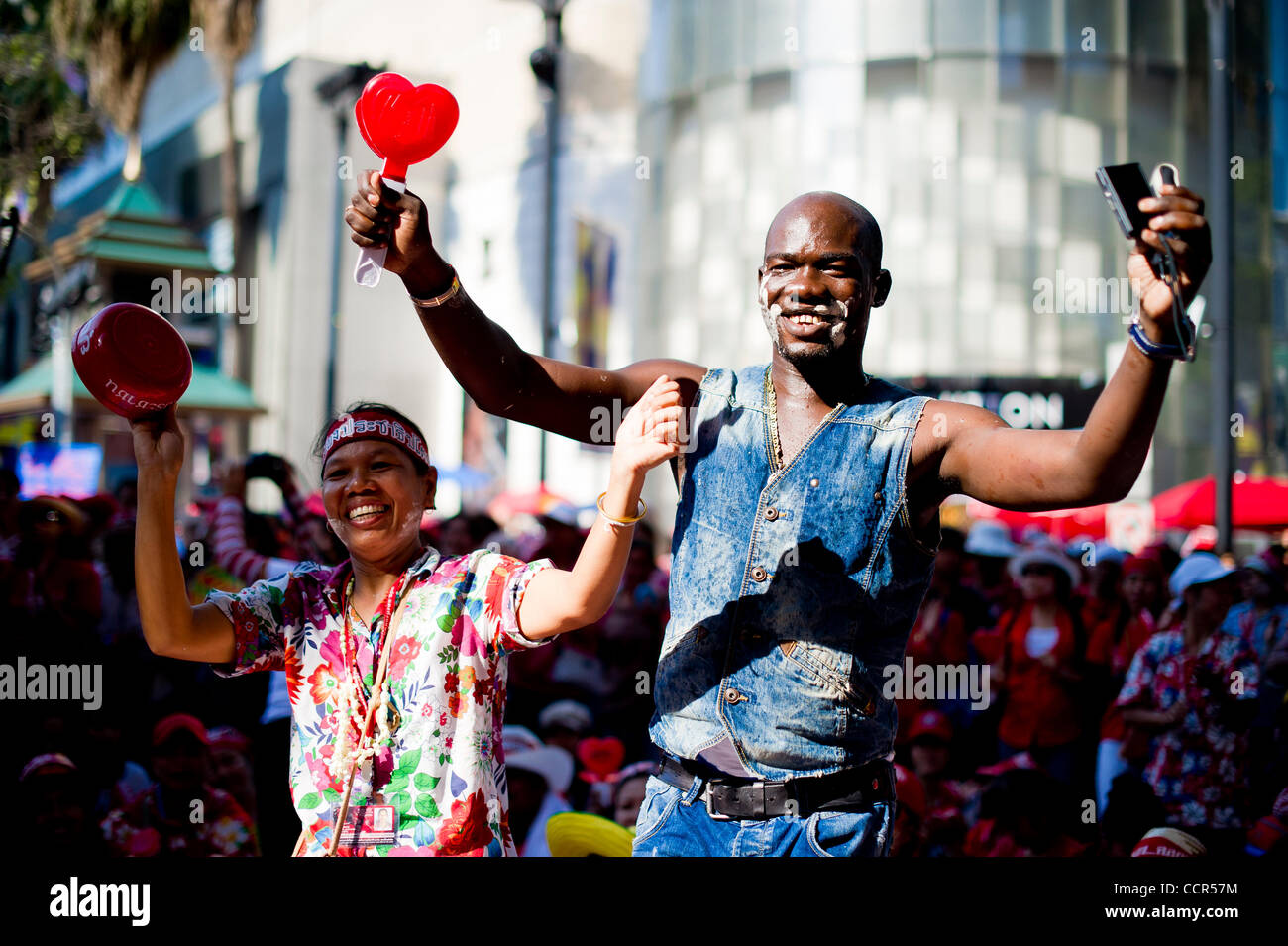 A member of Red Shirts and a tourist dances during the Songkran ...